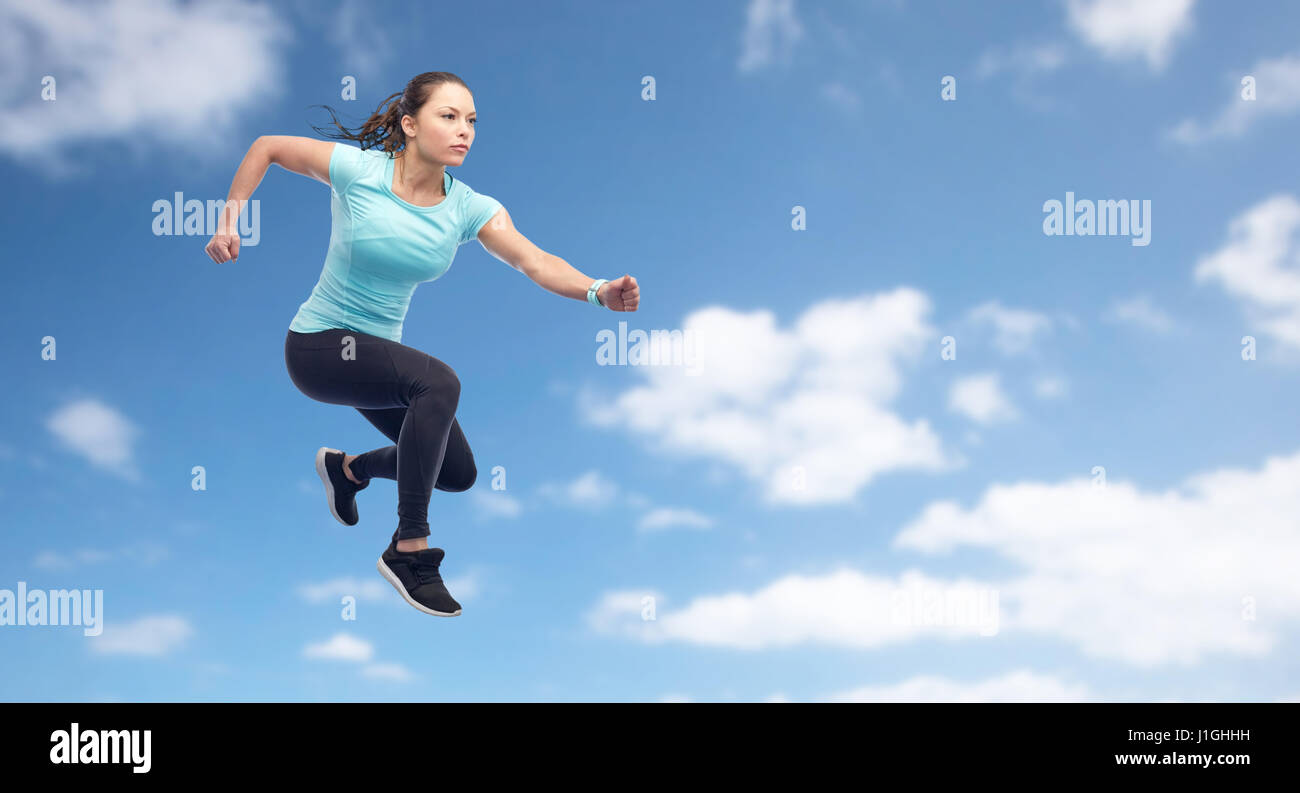happy sporty young woman jumping in air Stock Photo - Alamy