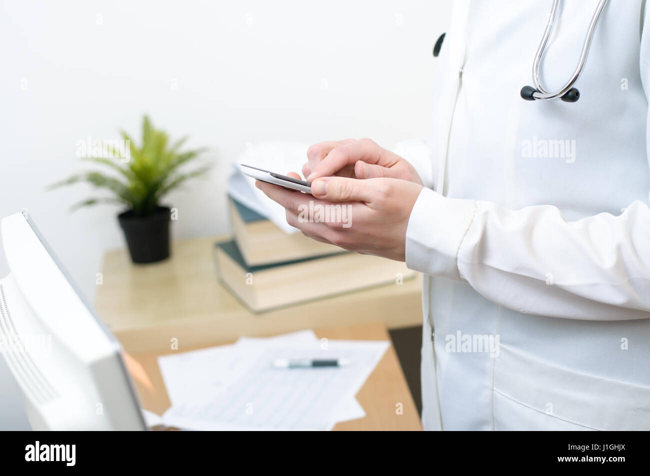 A female doctor texting on smartphone in medical office Stock Photo - Alamy