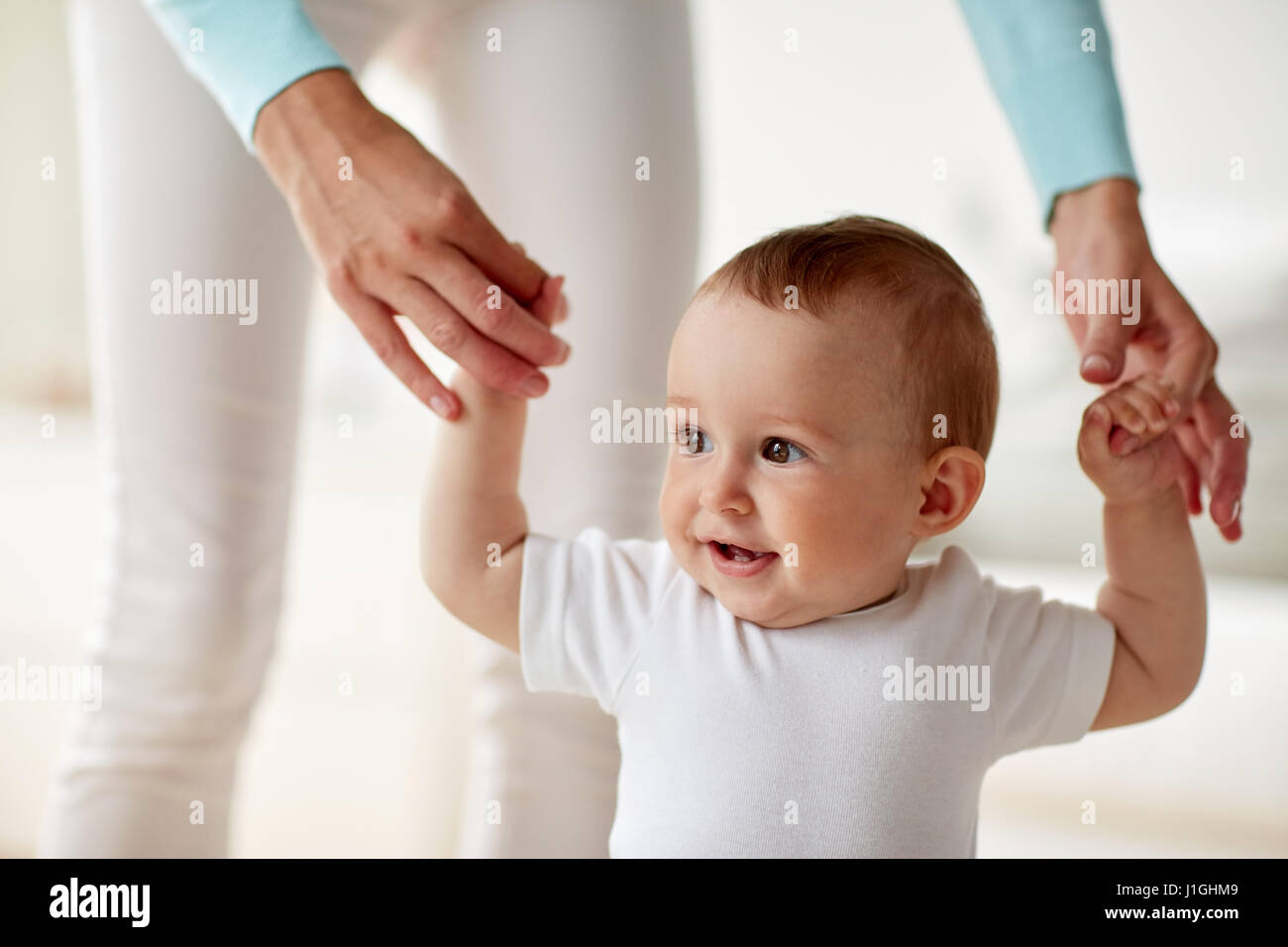 happy baby learning to walk with mother help Stock Photo - Alamy