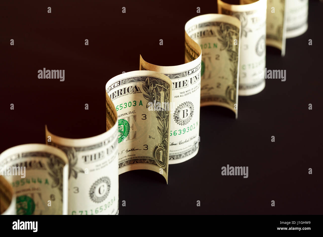 Few one dollar bank notes curved as sign on dark background Stock Photo ...
