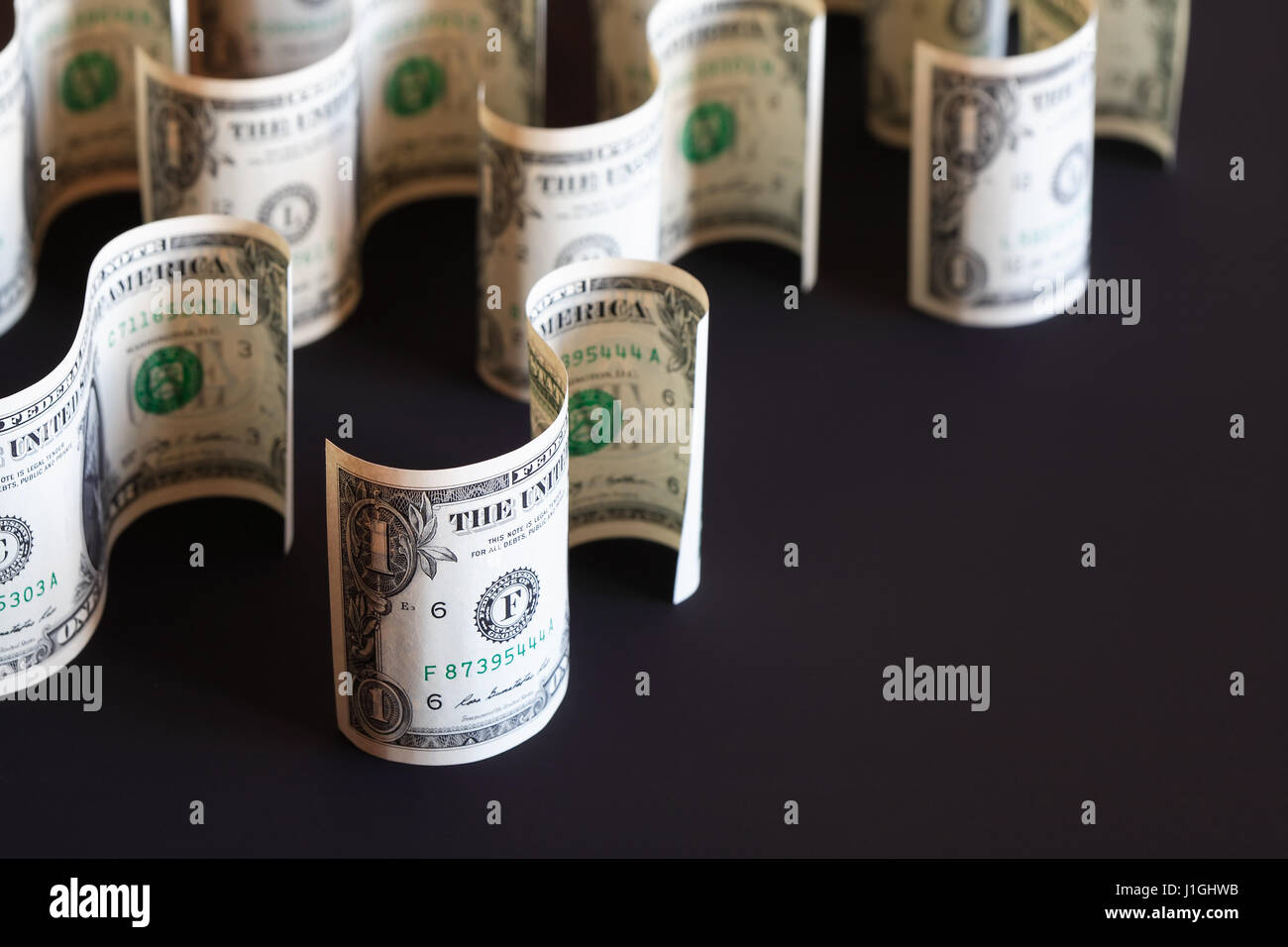 Few one dollar bank notes curved as sign on dark background Stock Photo ...