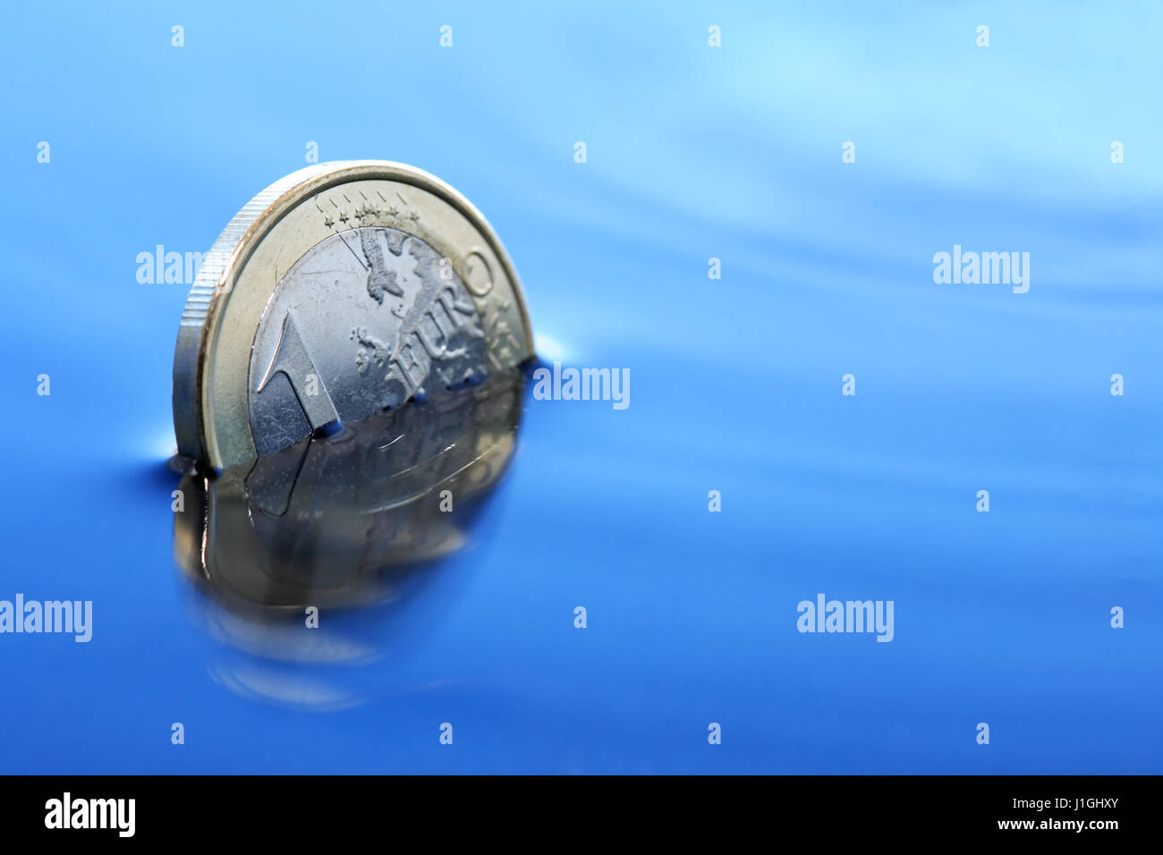 Economy crisis concept. Closeup of one euro coin sinking in water Stock ...