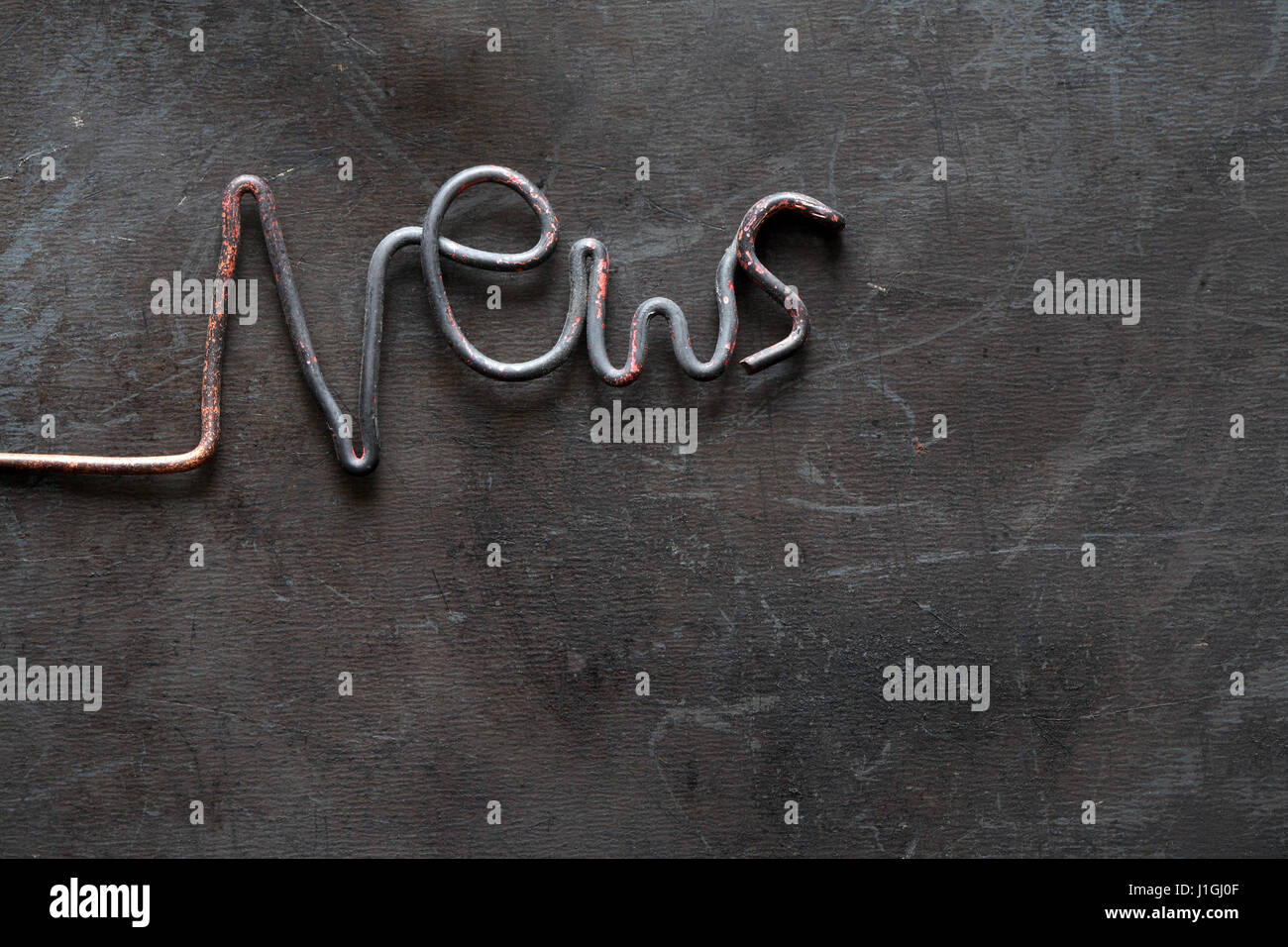 Periodical Press concept. Word News made from metal wire on grange dark ...