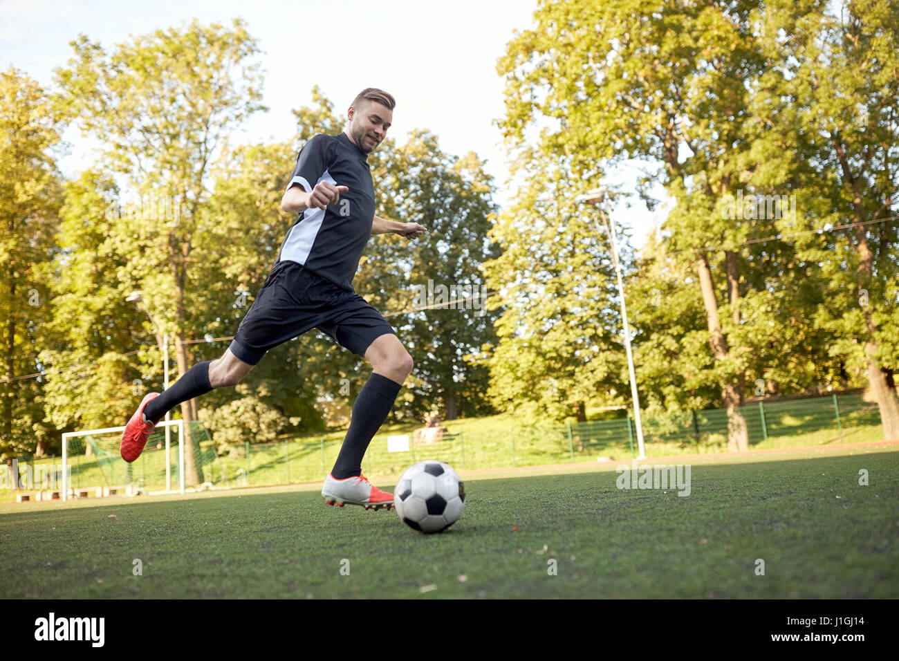 soccer player playing with ball on football field Stock Photo - Alamy