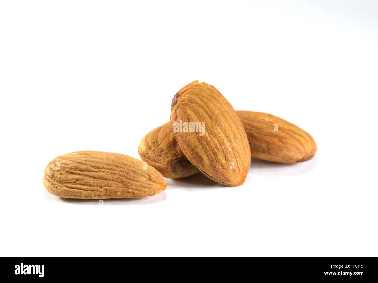 Extreme closeup of few almonds on white background Stock Photo - Alamy