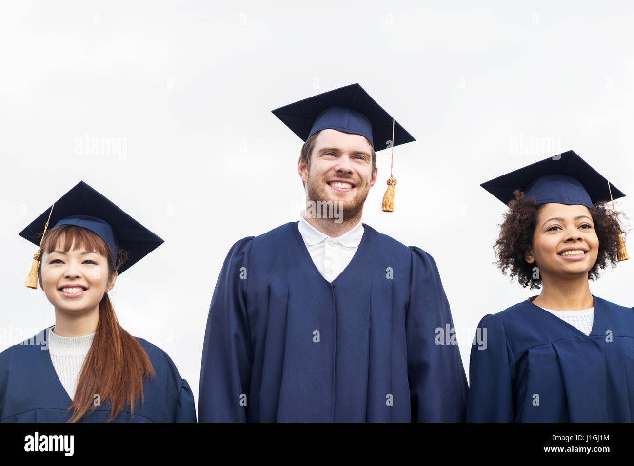 happy students or bachelors in mortar boards Stock Photo - Alamy