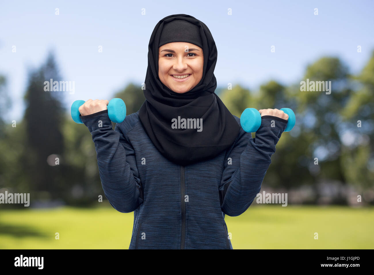 muslim woman in hijab with dumbbells doing fitness Stock Photo - Alamy