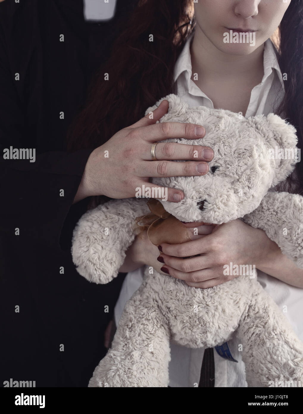 priest holding a teddy bear and young girl Stock Photo - Alamy
