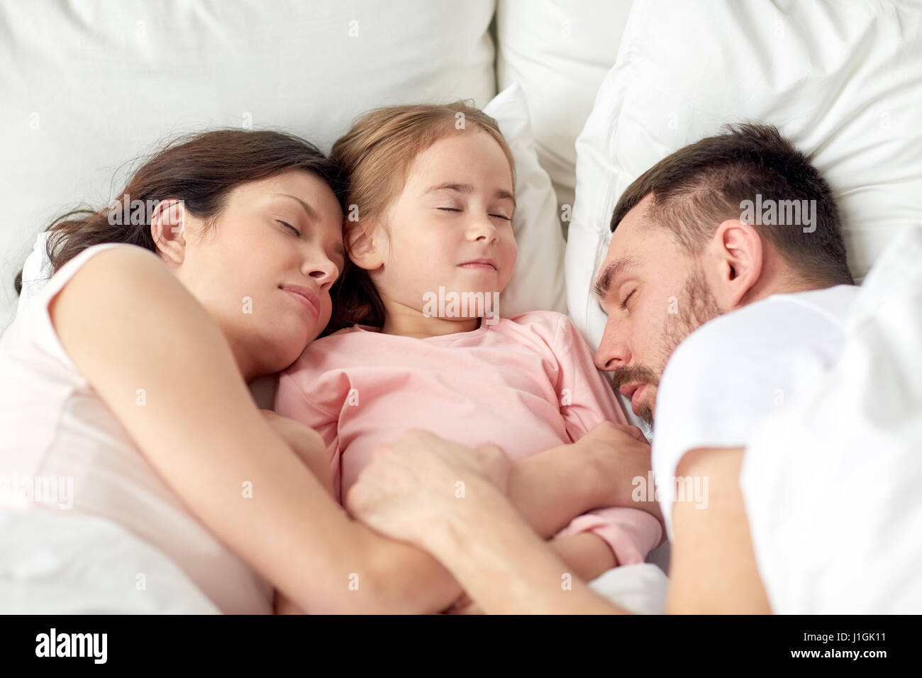 happy family sleeping in bed at home Stock Photo - Alamy