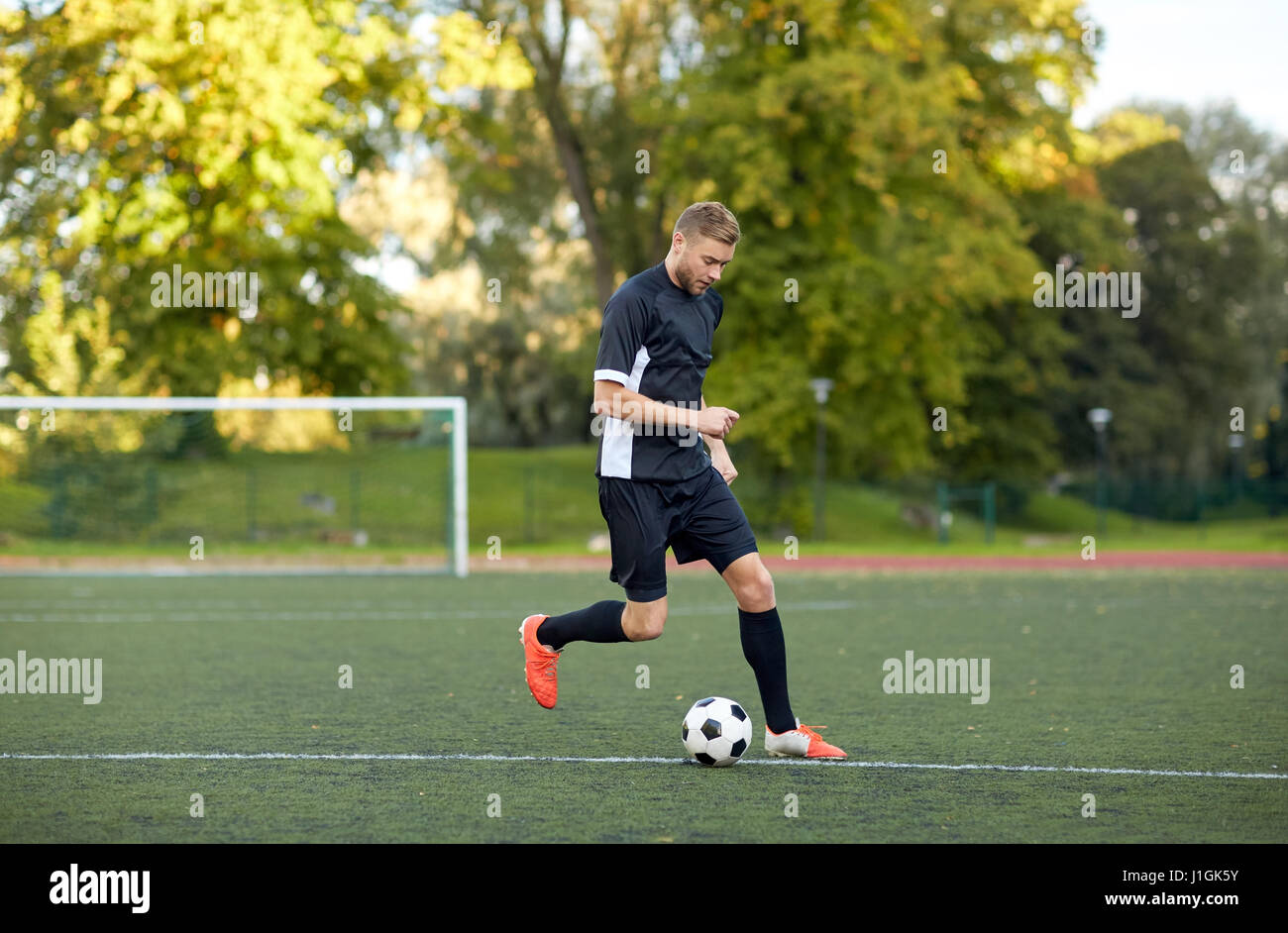 soccer player playing with ball on football field Stock Photo - Alamy