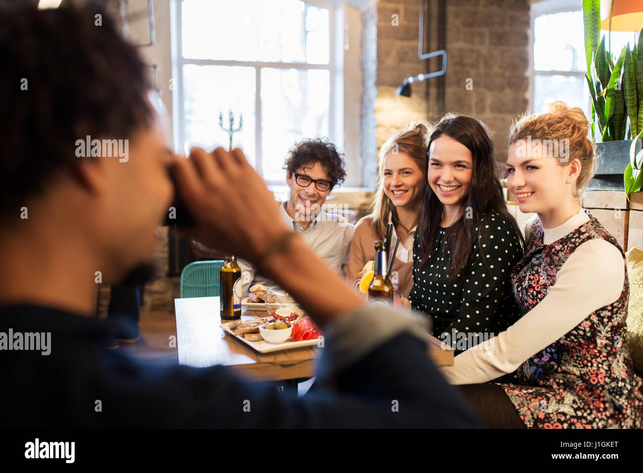 friends with camera photographing at bar or cafe Stock Photo - Alamy