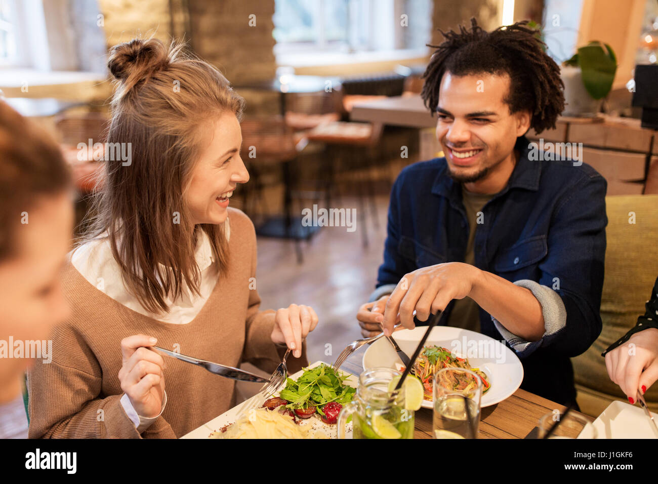 happy friends eating and drinking at restaurant Stock Photo - Alamy