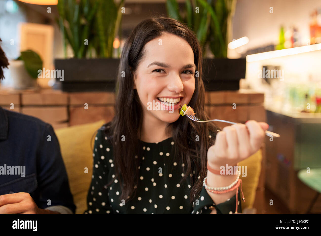 happy young woman eating at restaurant Stock Photo - Alamy