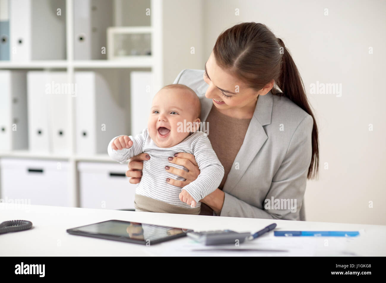 happy businesswoman with baby working at office Stock Photo - Alamy