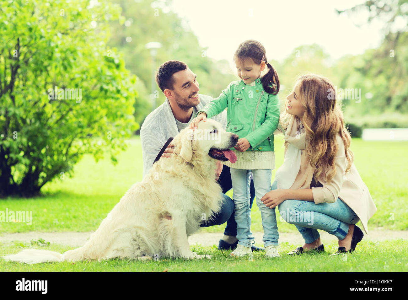 happy family with labrador retriever dog in park Stock Photo - Alamy