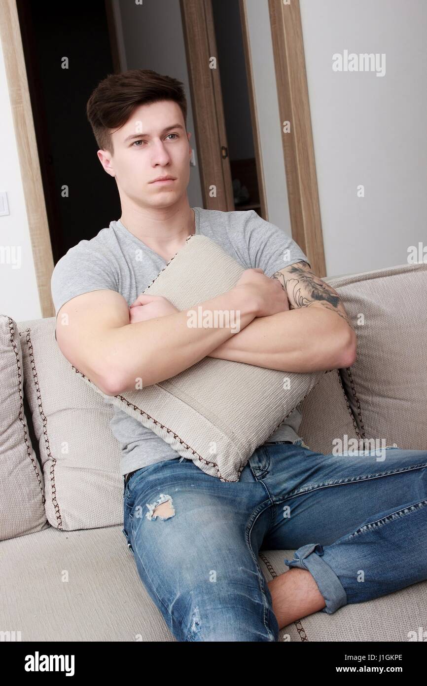 Portrait of a casual tired man resting sitting on a couch at home Stock ...