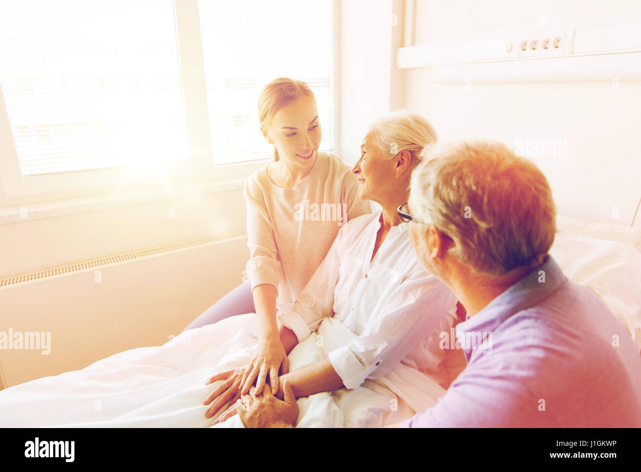 happy family visiting senior woman at hospital Stock Photo - Alamy