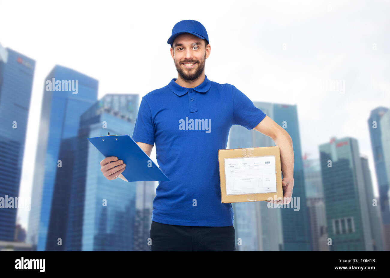 happy delivery man with parcel box and clipboard Stock Photo - Alamy