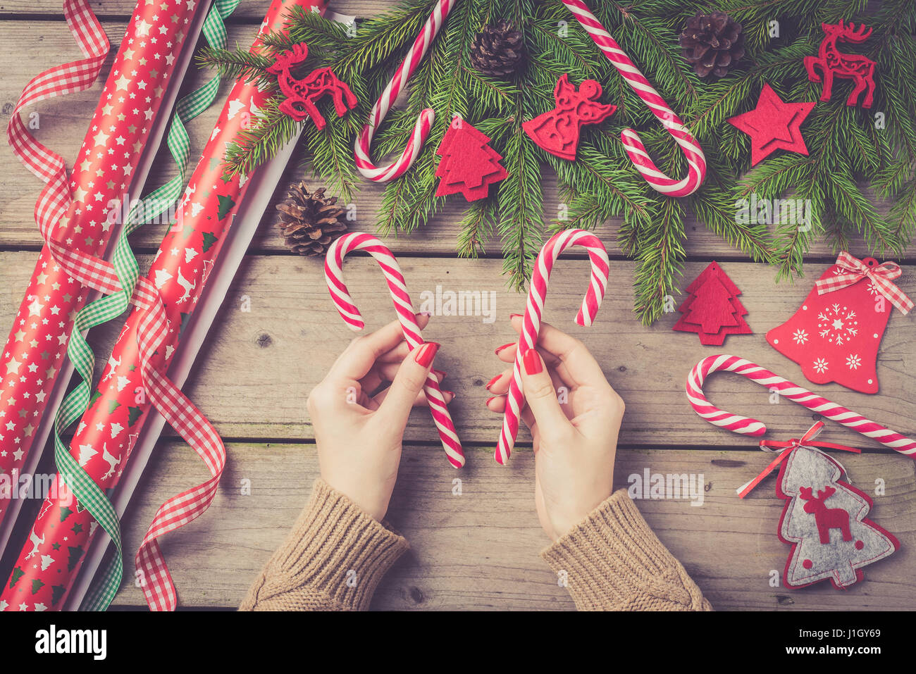Woman holding candy cane over wooden table. Christmas preparations ...