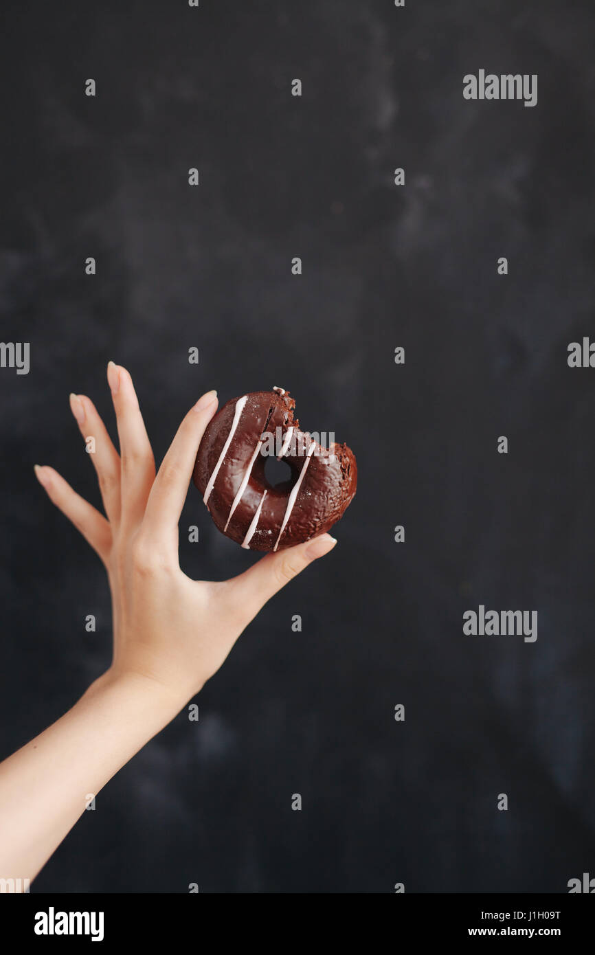 Chocolate strip donut in a woman's hand Stock Photo - Alamy