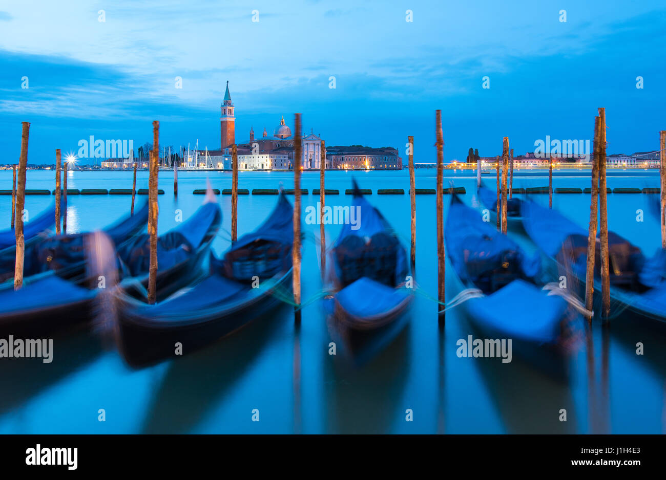 Gondolas Moored Along Waterfront Of Saint Marks Square With Church Of