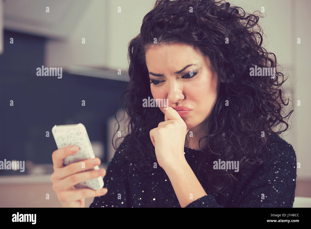 Upset confused young woman suing mobile phone reading text message ...
