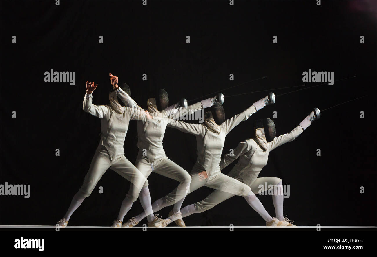 Full-length portrait of woman wearing white fencing costume on black ...