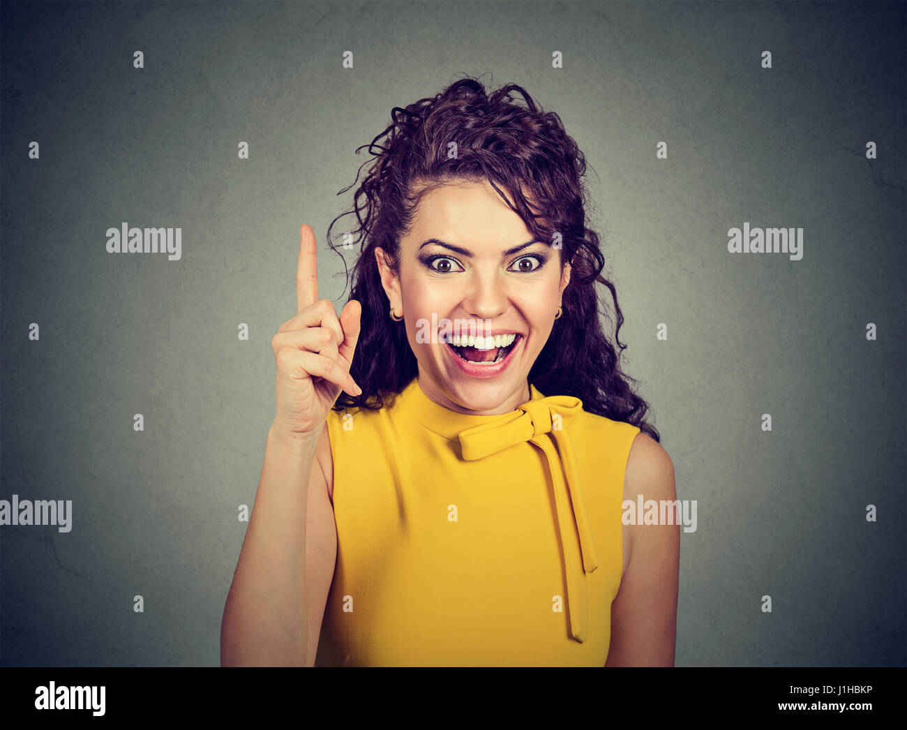 Attractive woman pointing finger up has an idea Stock Photo - Alamy