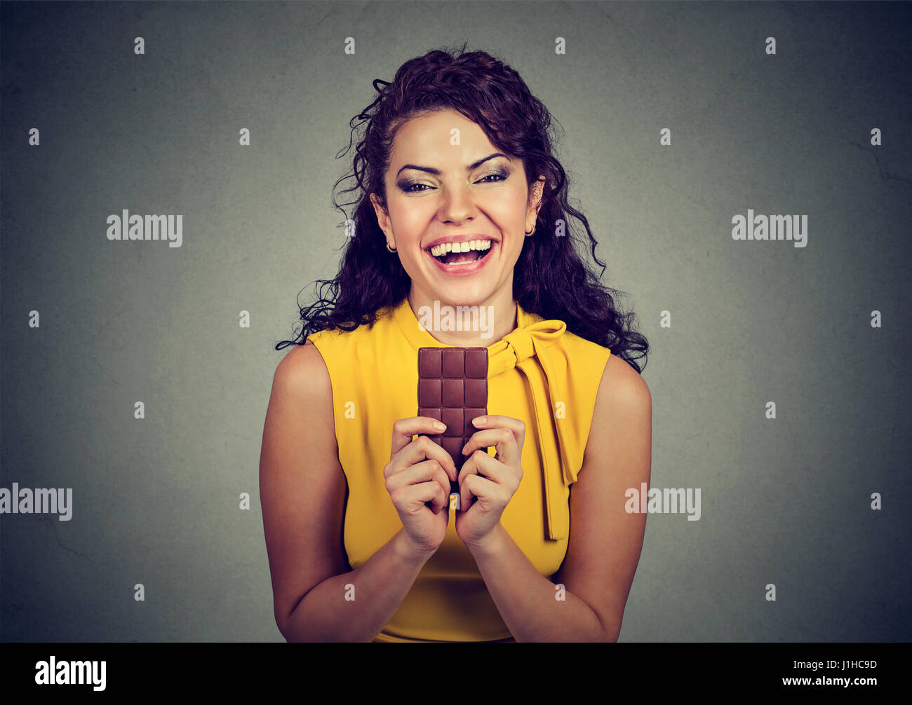 Woman with chocolate laughing isolated on gray background Stock Photo ...