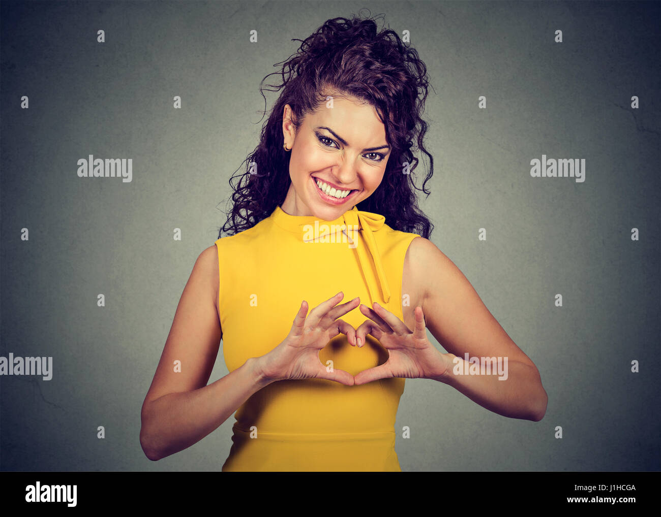 Smiling cheerful happy woman making heart sign with hands Stock Photo ...
