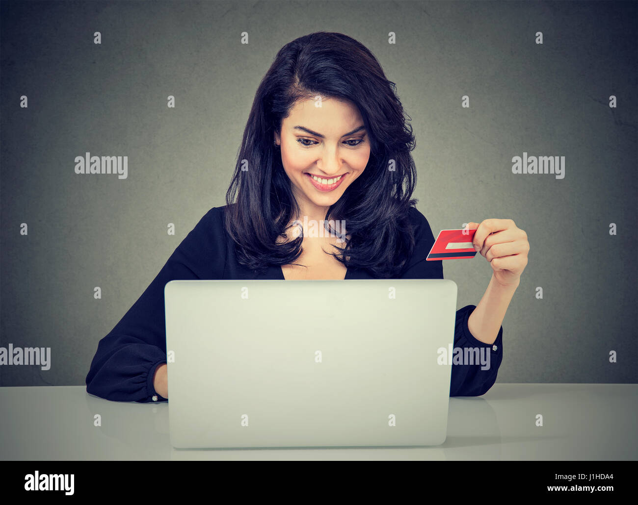 Internet shopping and payment. Smiling young woman holding credit card ...