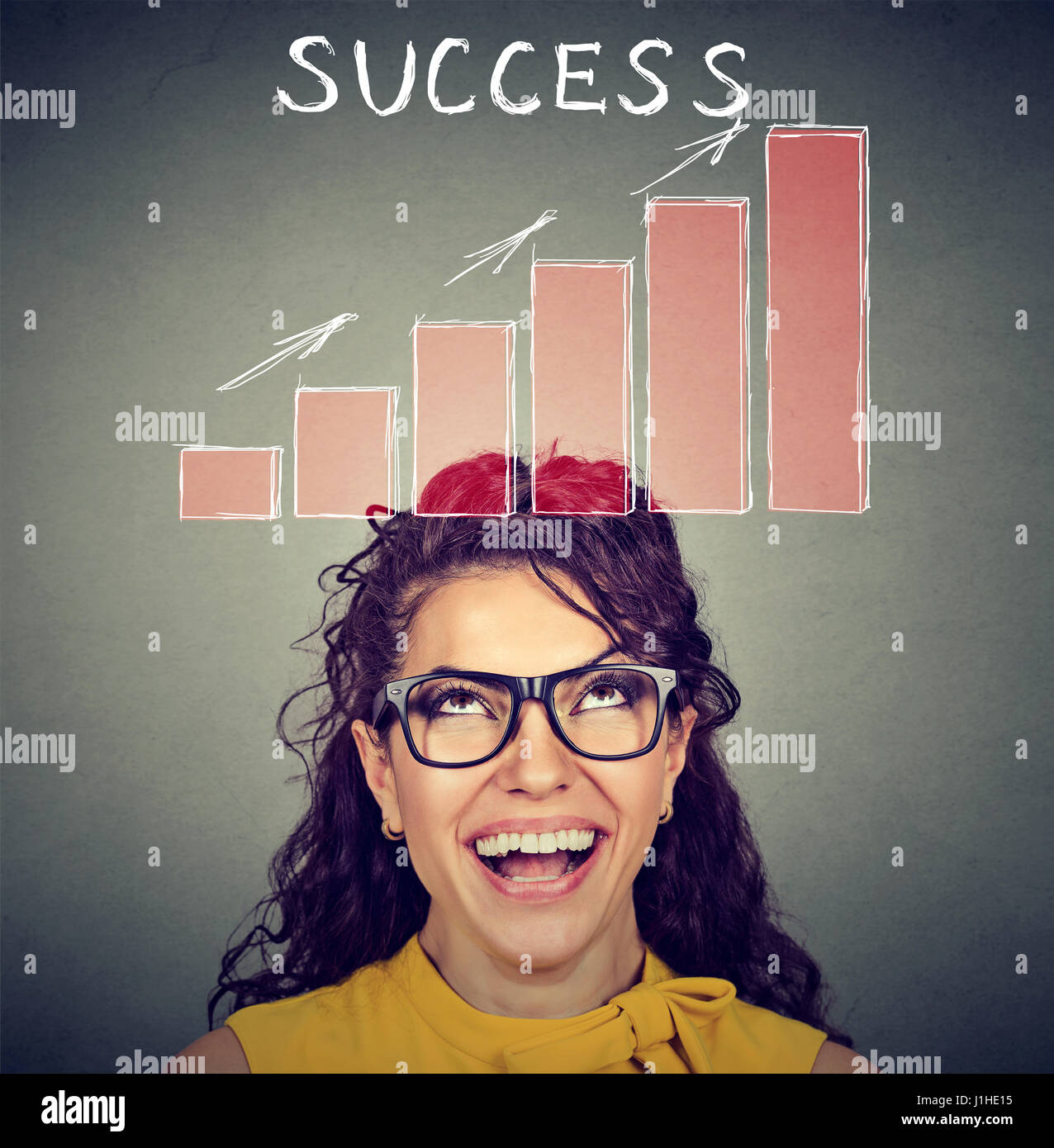 Happy young successful woman looking up at growing chart Stock Photo ...