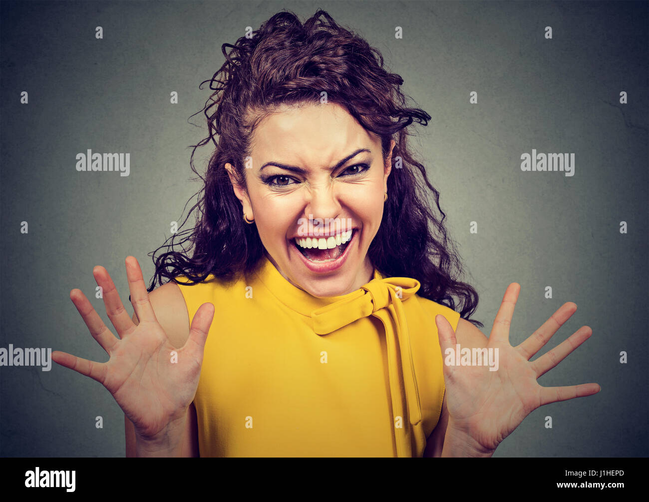 Joyful girl. Very happy woman shouting isolated on gray background ...