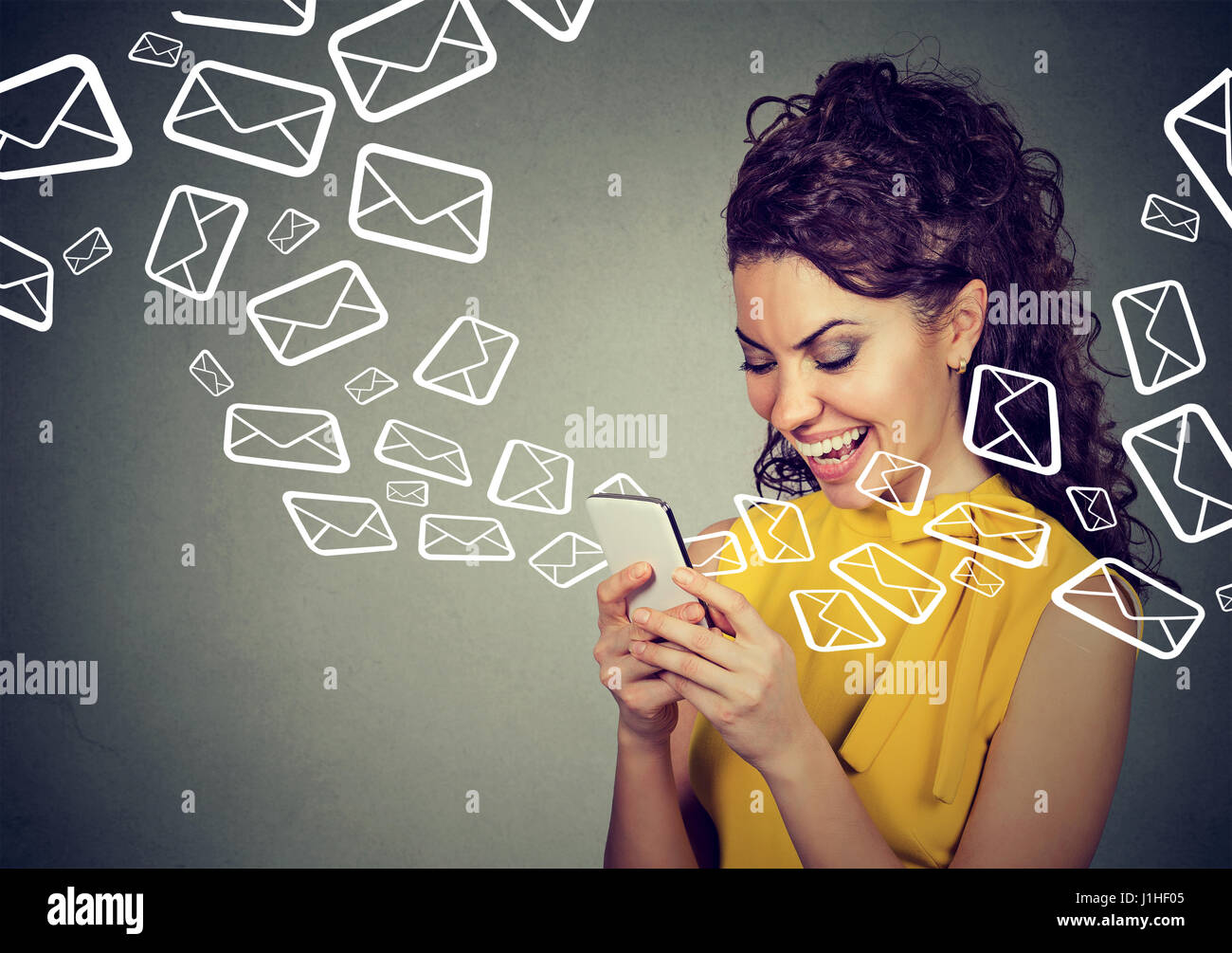 Happy woman busy sending messages on smart phone email icons flying out ...