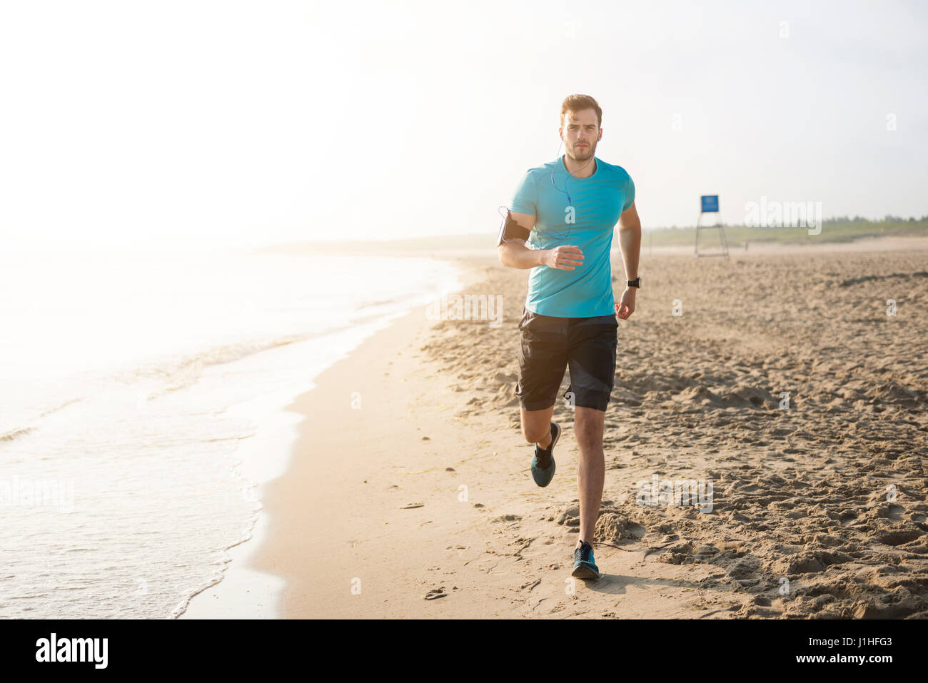 Handsome man running on the beach Stock Photo - Alamy
