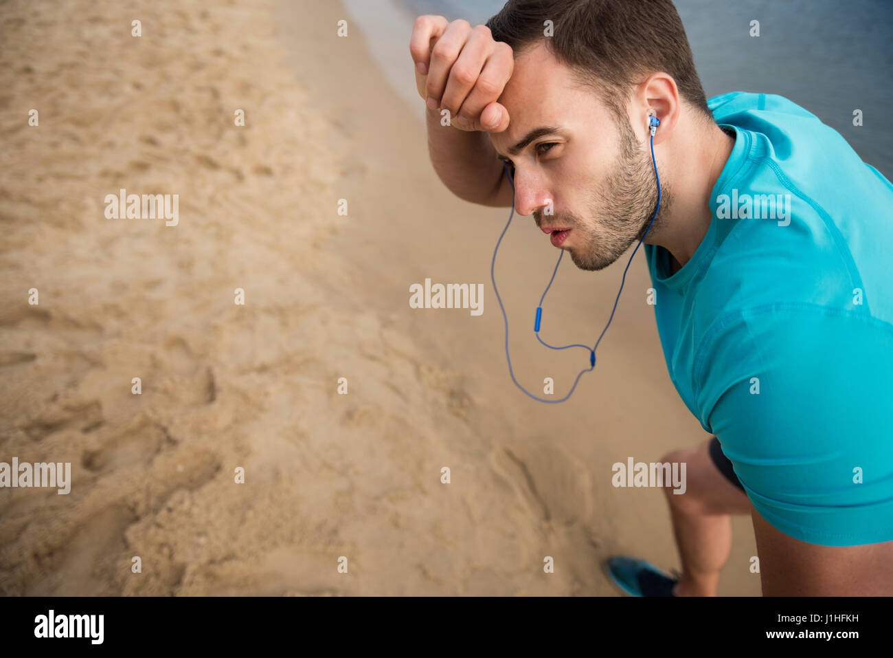 Man wiping sweat from his forehead Stock Photo - Alamy