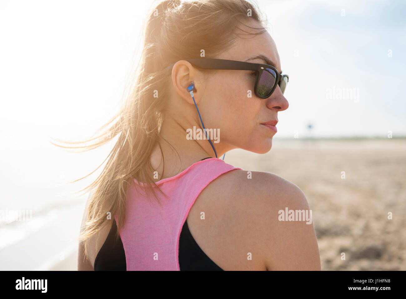 Woman looking behind at the beach Stock Photo - Alamy