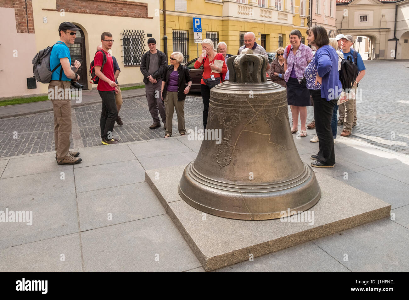 Tourist group viewing the bronze bell located in Kanonia Square, Old ...