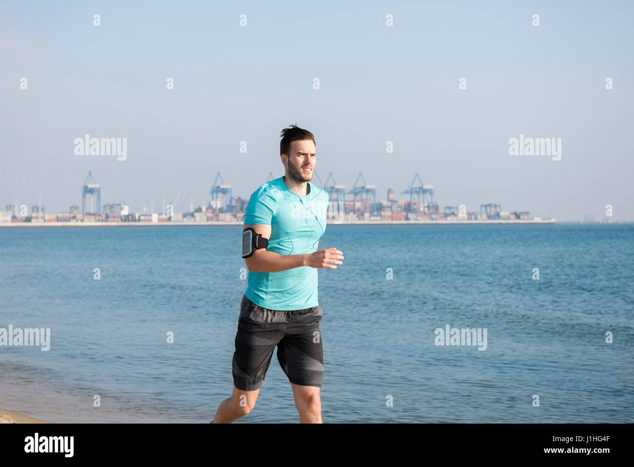 Handsome man running by the sea Stock Photo - Alamy