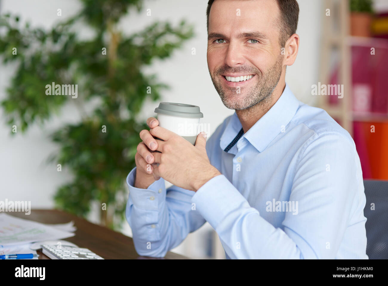 Man with coffee next to the computer Stock Photo - Alamy