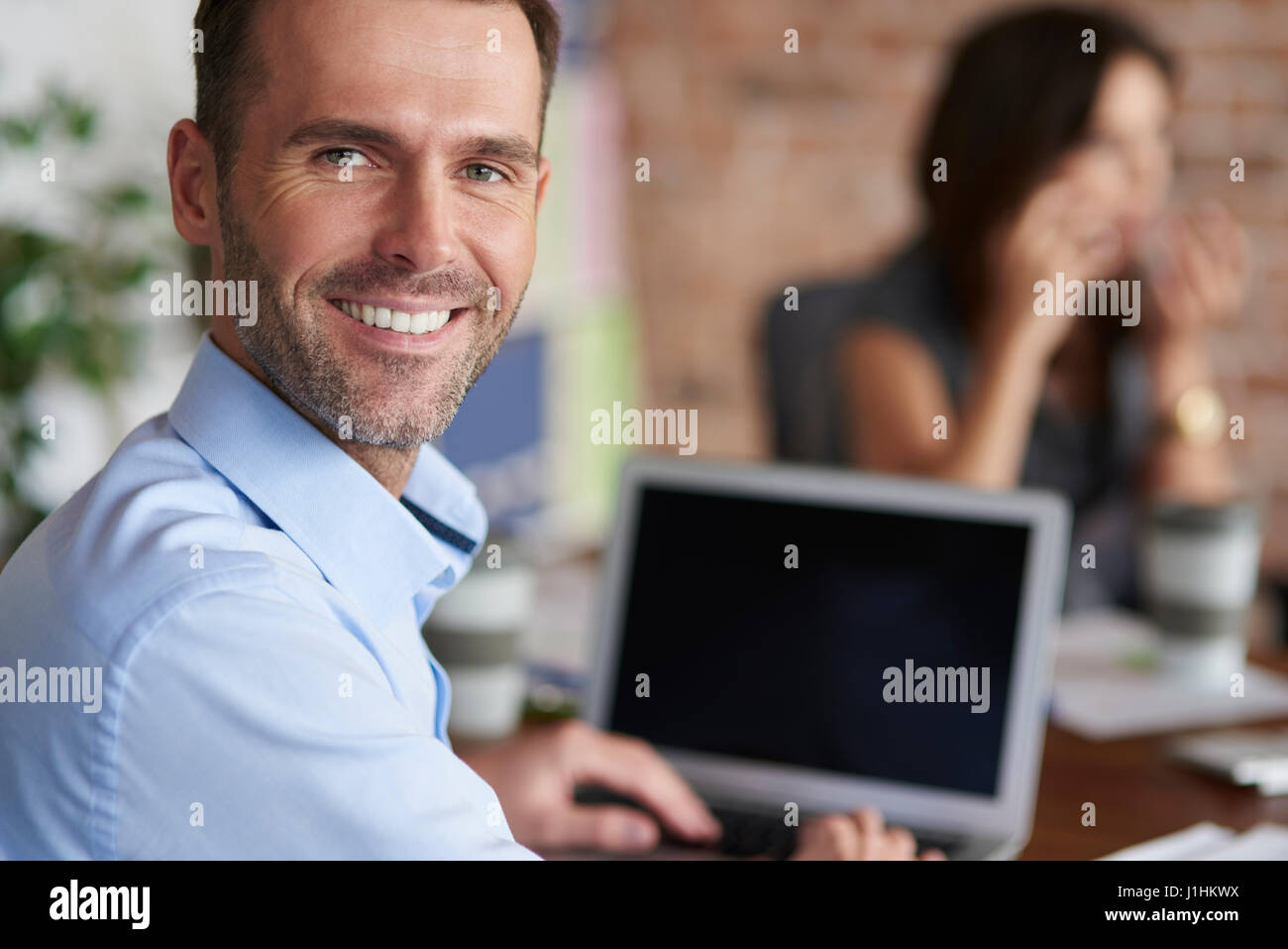 Portrait of cheerful man in front of computer Stock Photo - Alamy