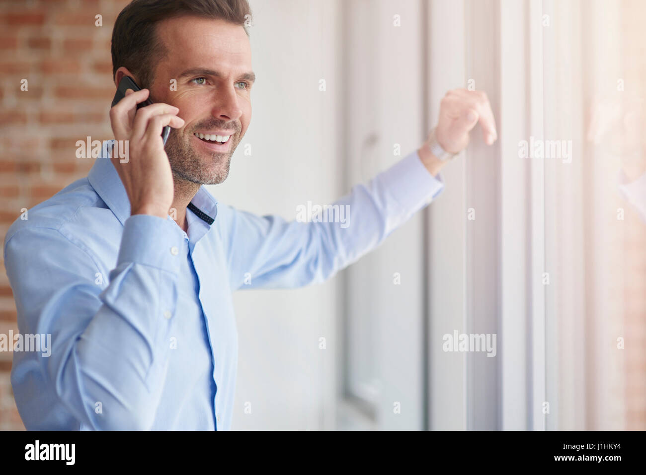 Businessman next to the window Stock Photo - Alamy