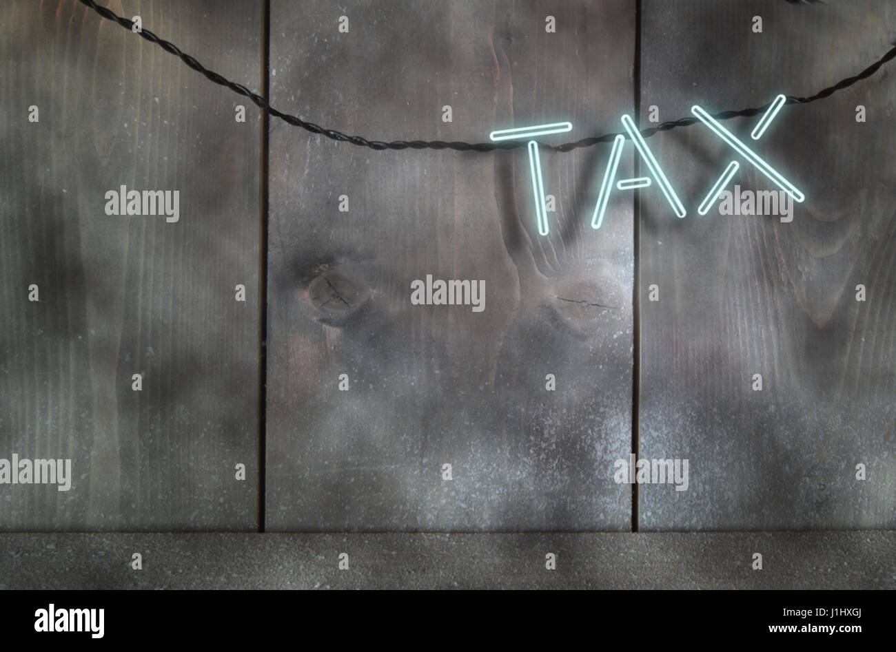 Neon text spelling tax against a wall Stock Photo - Alamy
