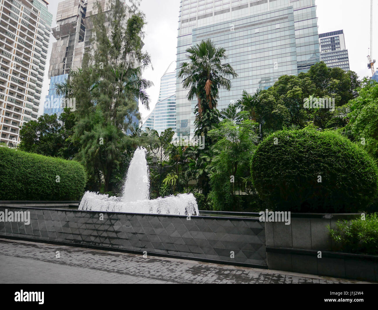 Side view of fountain in the garden which surrounded by business ...