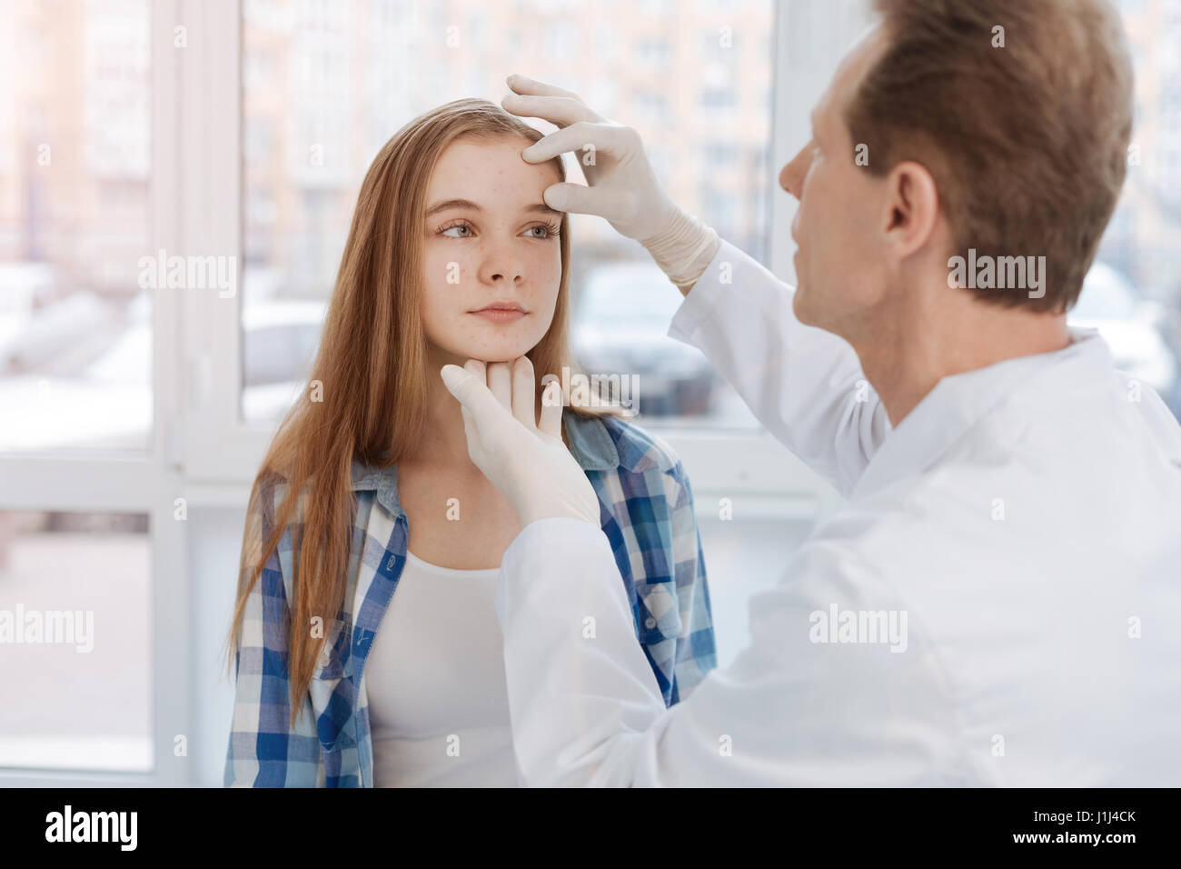 Aged dermatologist touching patient face in the clinic Stock Photo - Alamy