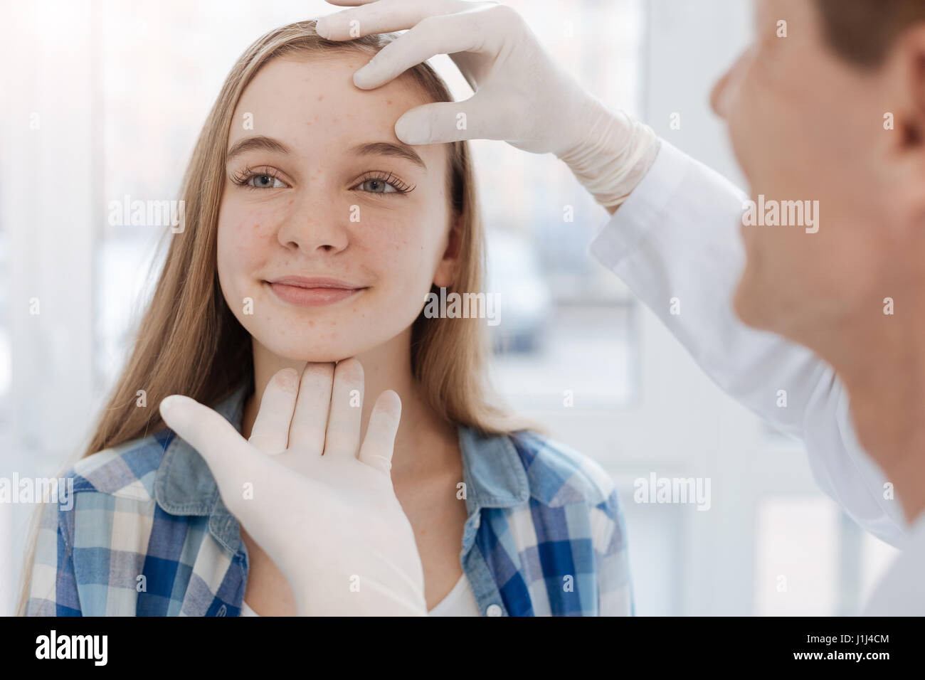 Careful dermatologist examining patient face at work Stock Photo - Alamy