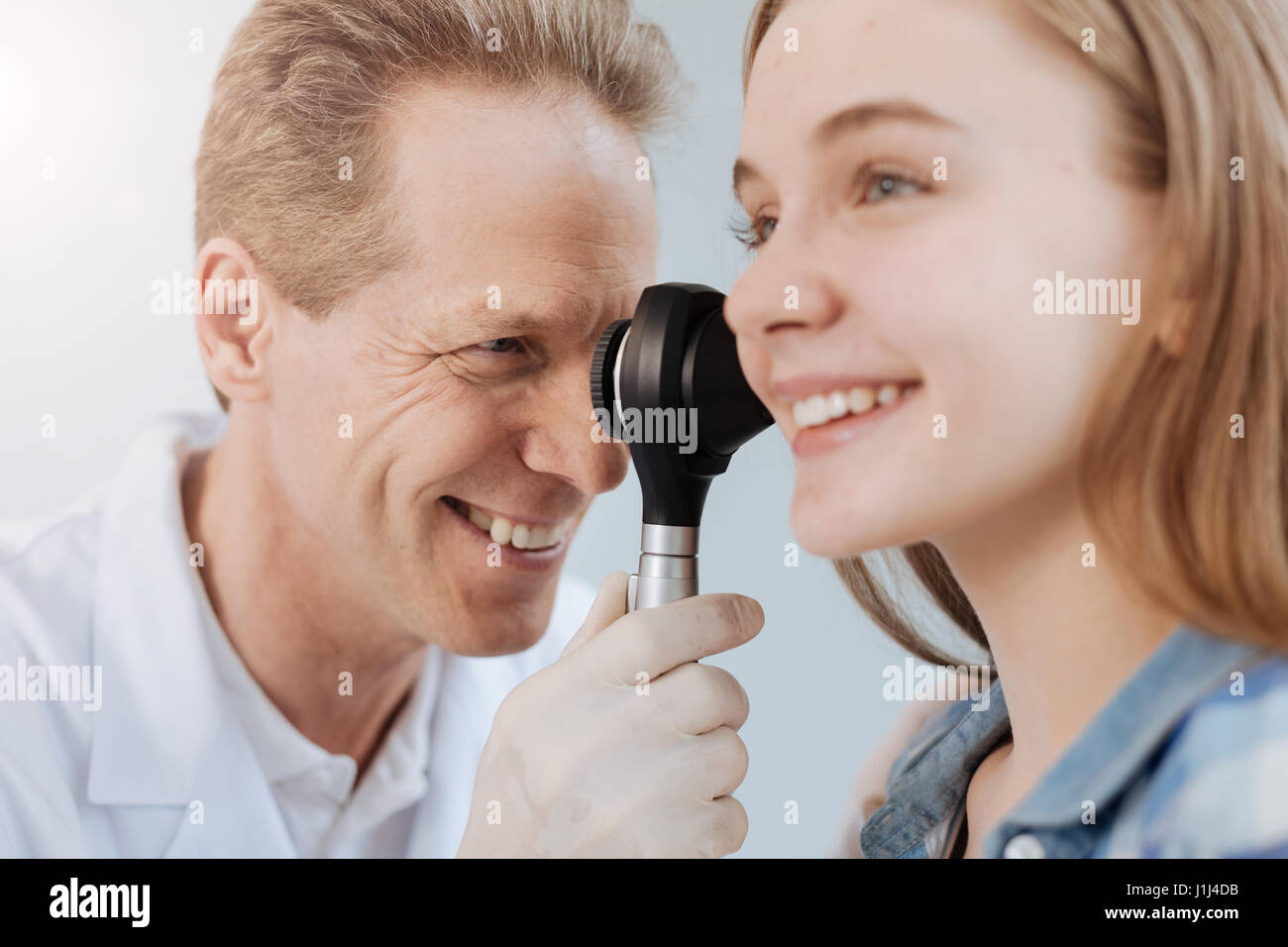 Friendly dermatologist using professional equipment in the hospital ...