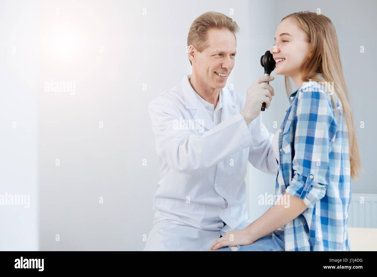 Qualified smiling doctor using dermatoscope at work Stock Photo - Alamy