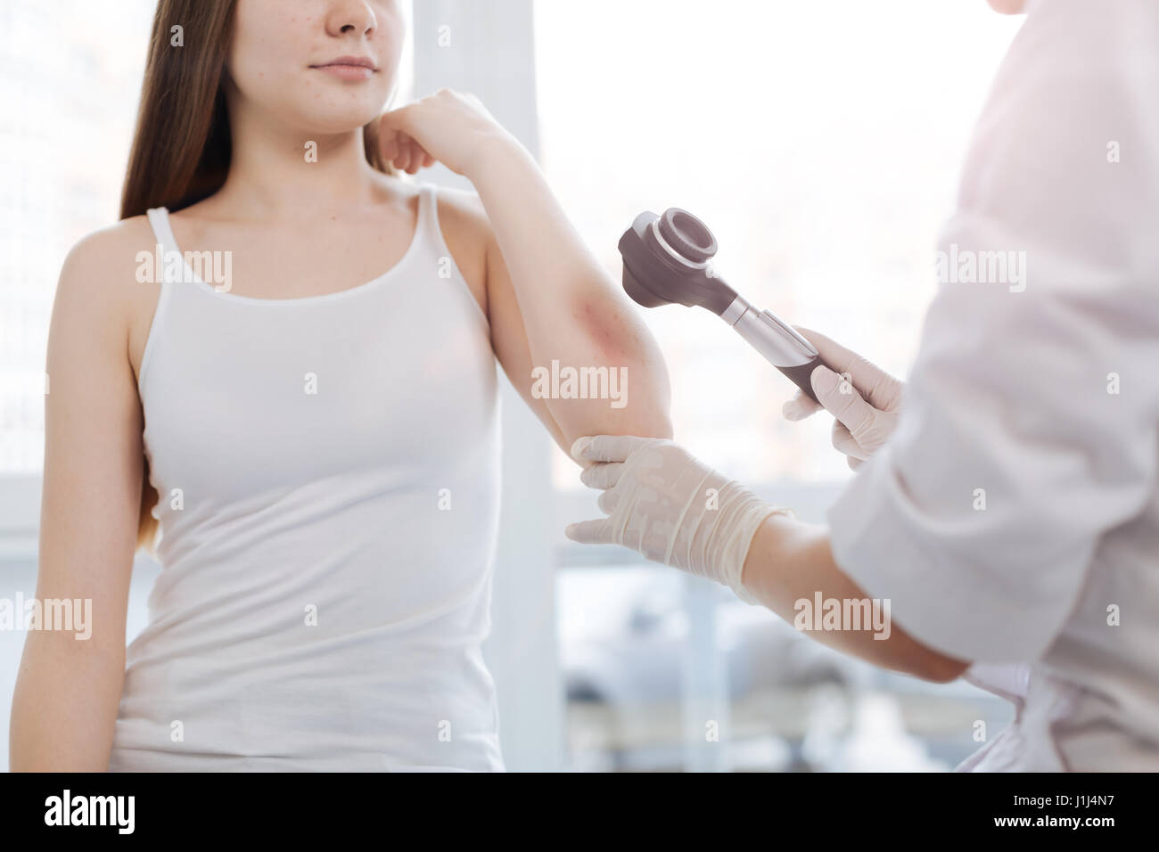 Helpful dermatologist using dermatoscope for allergy examination in the ...
