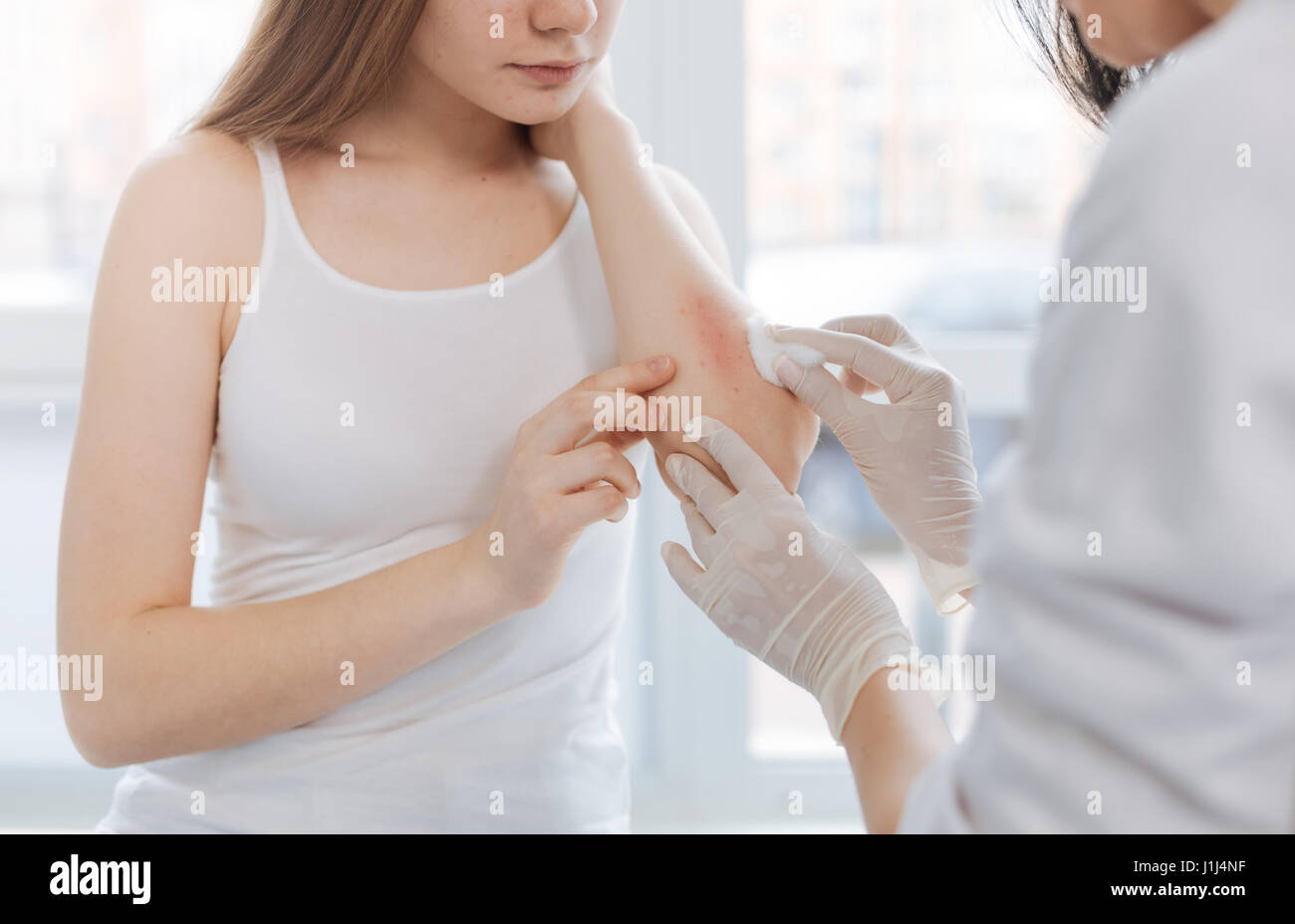 Helpful nurse using cotton for injury disinfection in the hospital ...